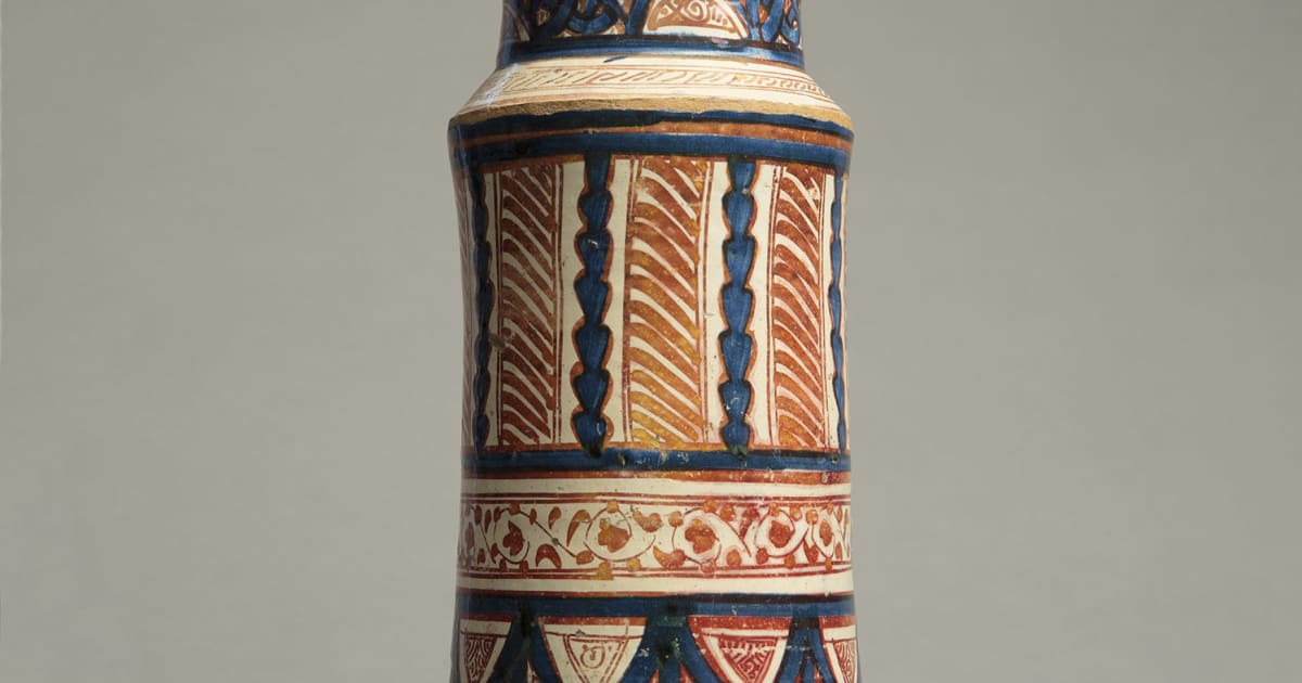 A slender albarello decorated with trelliswork, tendrils, and pseudo ...